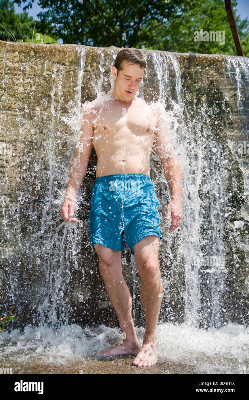 A man stands in a waterfall Stock Photo - Alamy