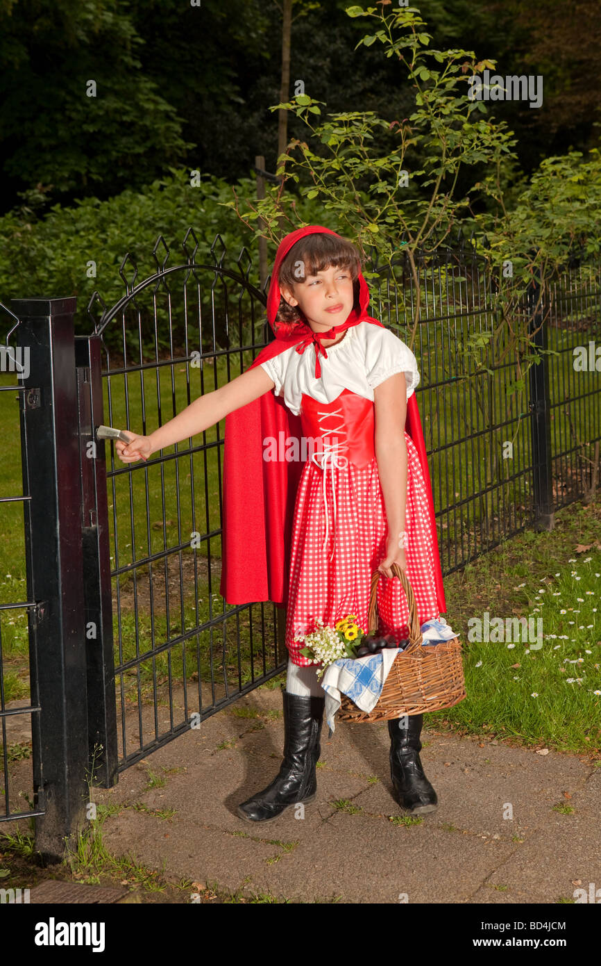 Little red riding hood opening the gate the her grandmother's cottage ...