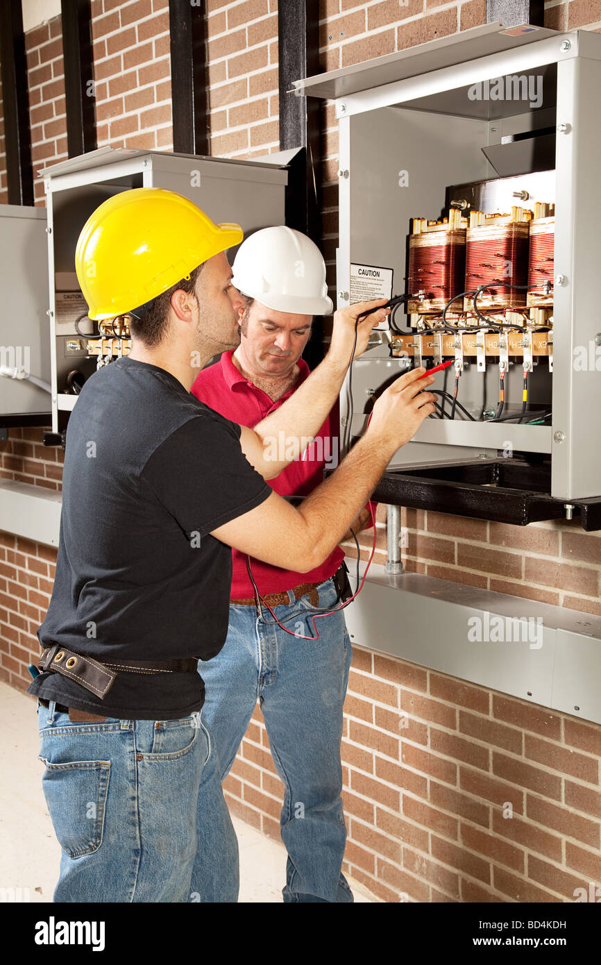 Workers testing the voltage of an industrial power distribution center ...