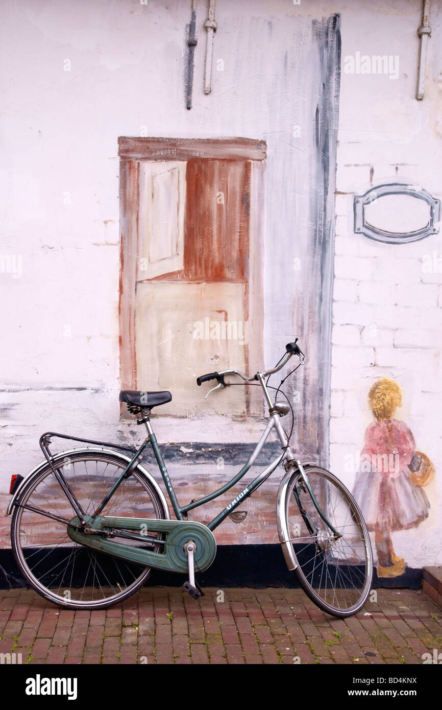 Bicycle against wall with painted scene Stock Photo - Alamy