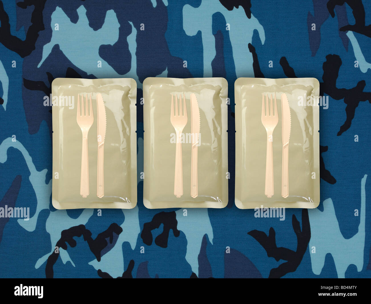 Three military food ration packages with utensils on a background of ...