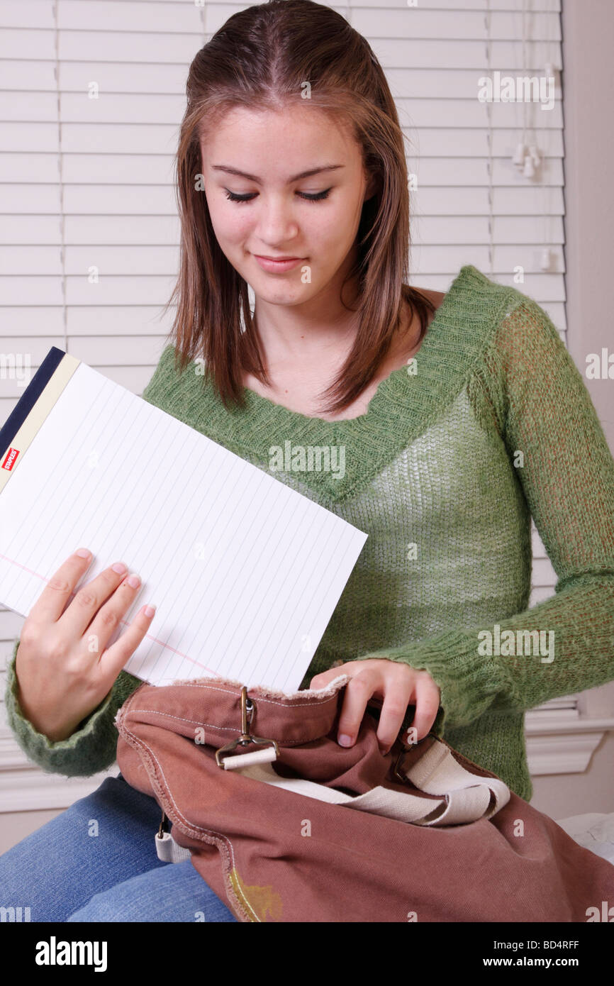 Student putting school supplies into backpack for school Stock Photo ...