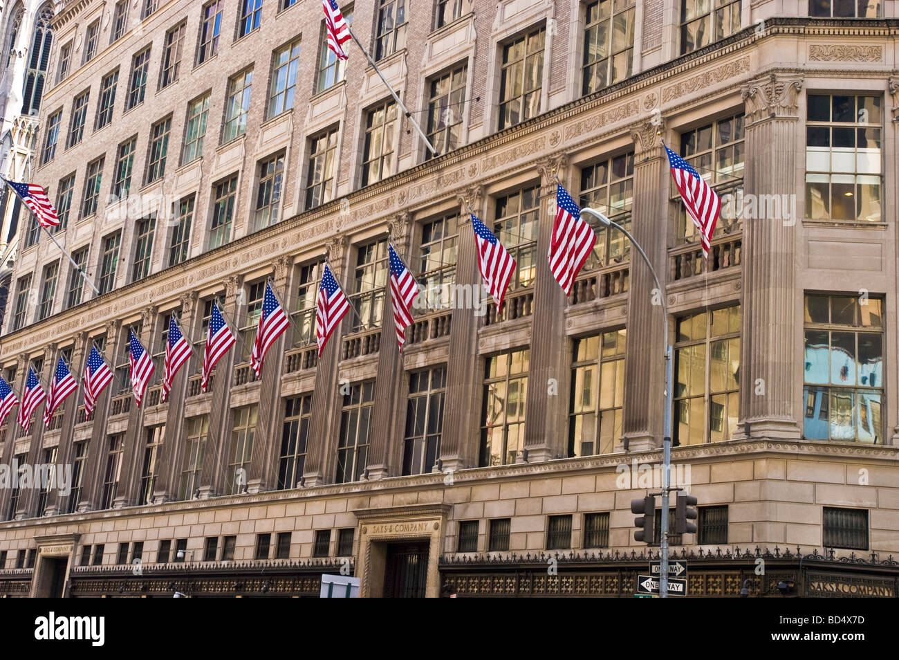 Row of American flags on Manhattan building with blue sky background ...