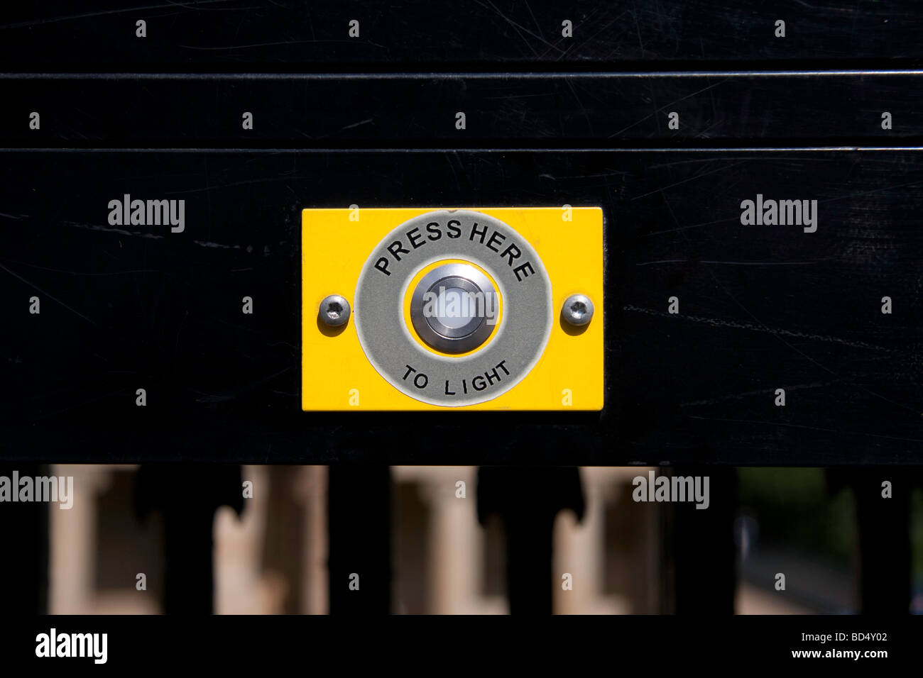 A button on an illuminated sign. The text reads "Press Here to light ...