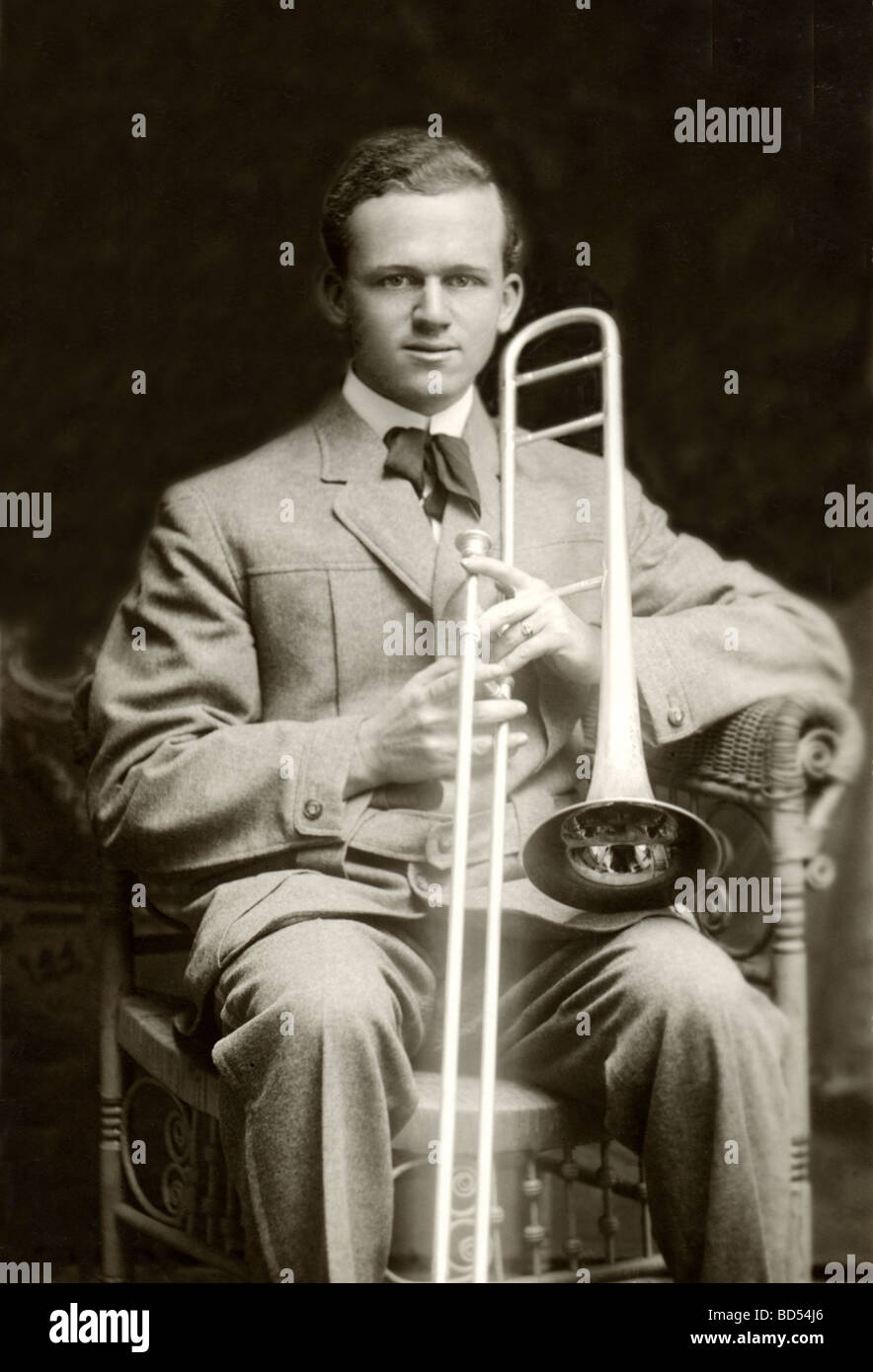 Musician in Wicker Chair Playing a Trombone Stock Photo - Alamy