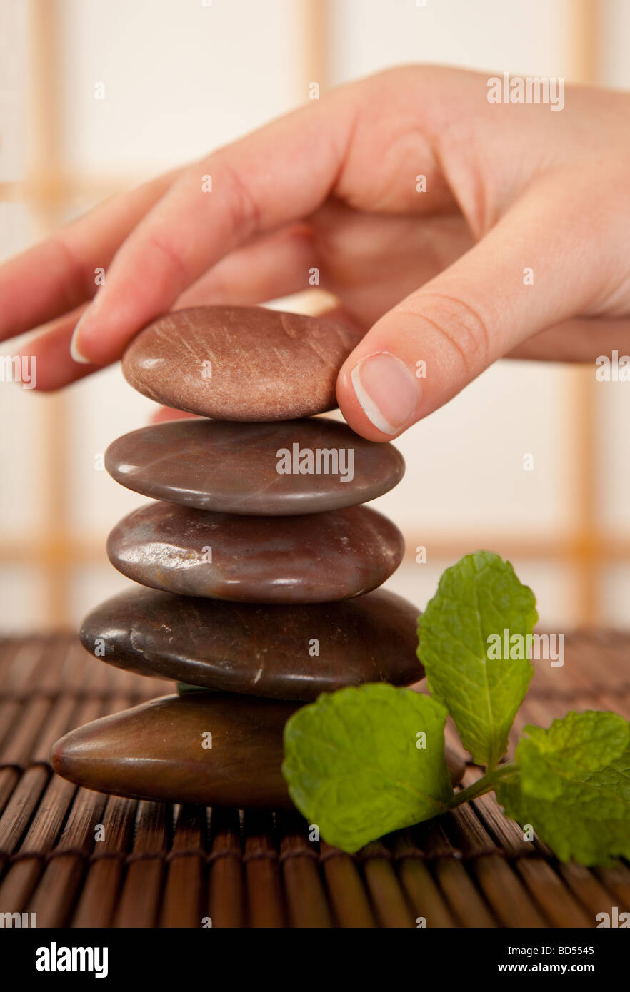 Female hand stacking traditional zen stones Stock Photo - Alamy
