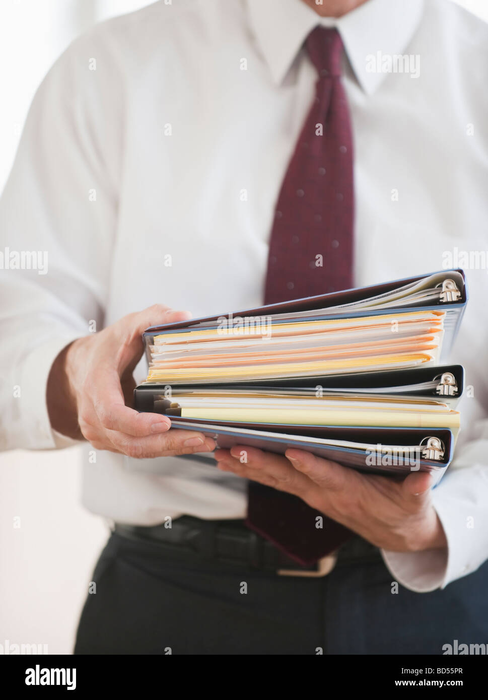 Businessman carrying binders Stock Photo - Alamy