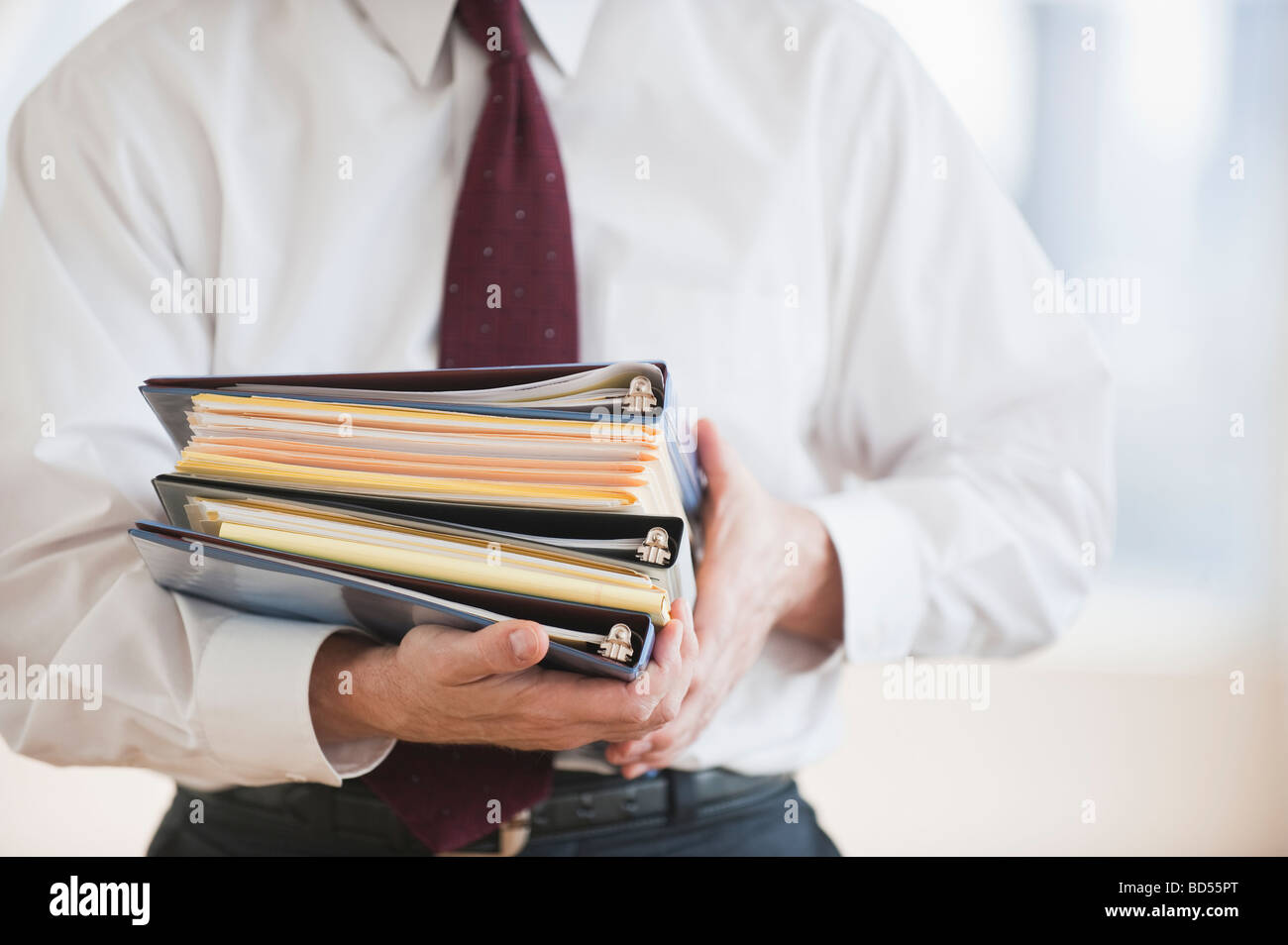 Businessman carrying binders Stock Photo - Alamy