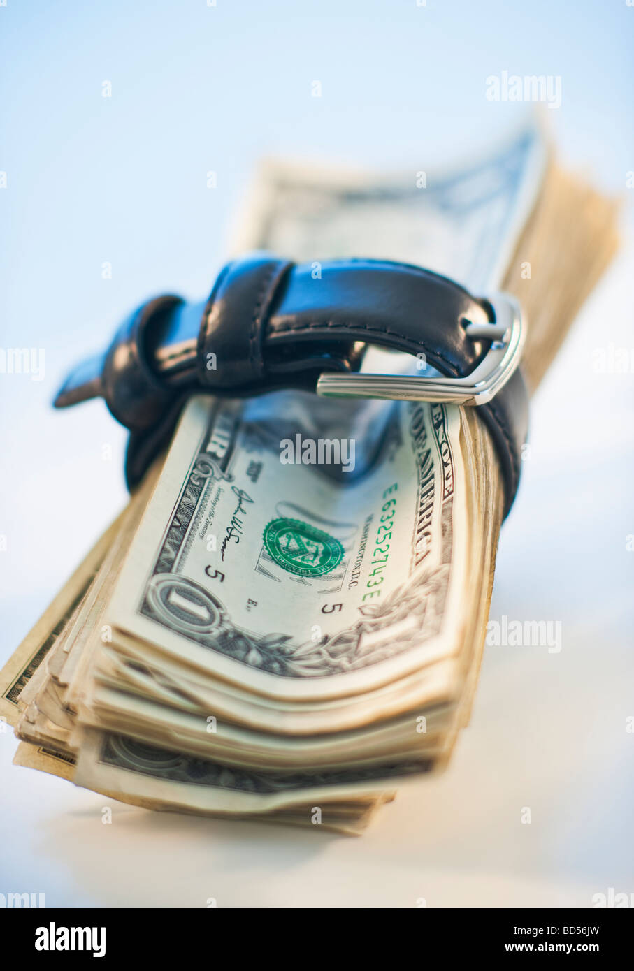 A watch around a stack of money Stock Photo - Alamy