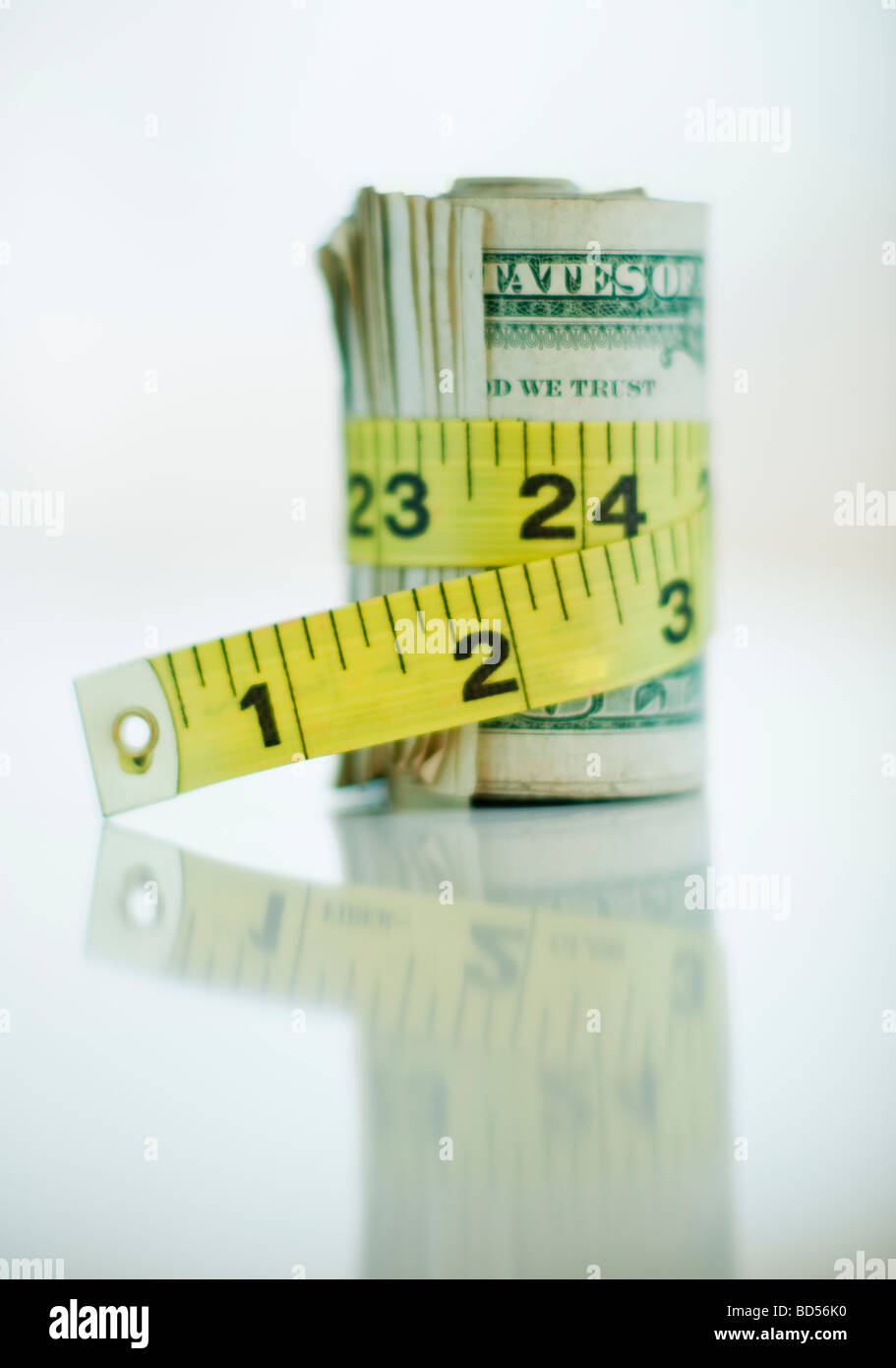 A measuring tape around bank notes Stock Photo - Alamy