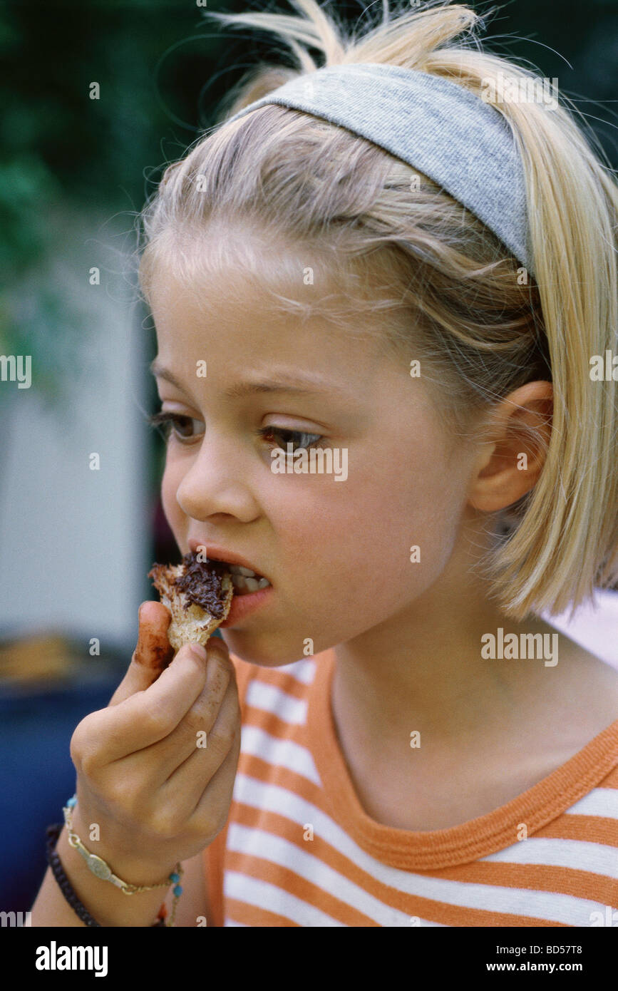 Little girl eating snack Stock Photo - Alamy