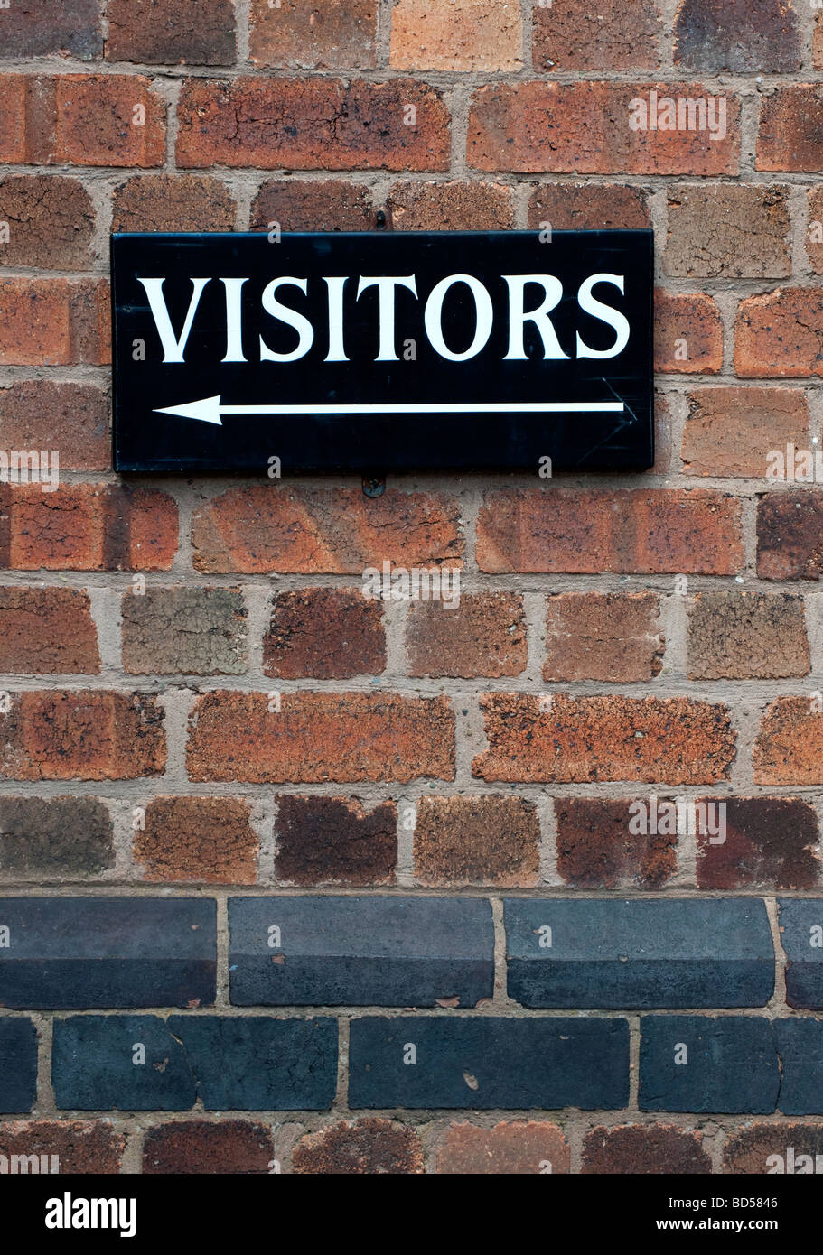 Visitors sign on brick wall Stock Photo - Alamy