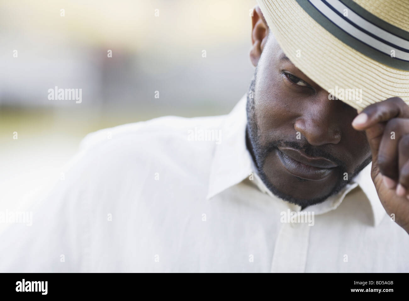 A man outdoors fixing his hat Stock Photo - Alamy