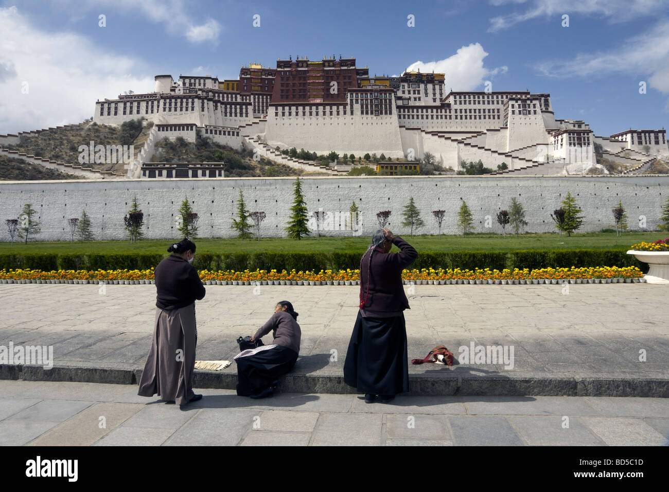 three tibetan women pilgrims in traditional clothing performing the ...