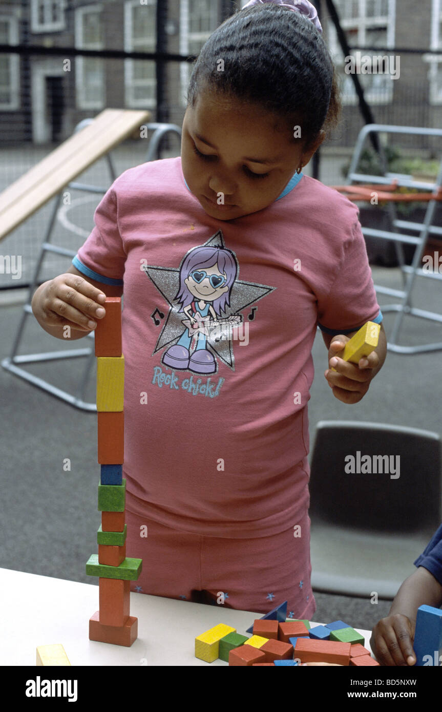 young black girl in primary school playground playing with building ...