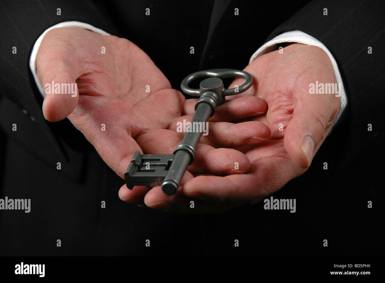 Hands holding a large key symbolizing success Stock Photo - Alamy