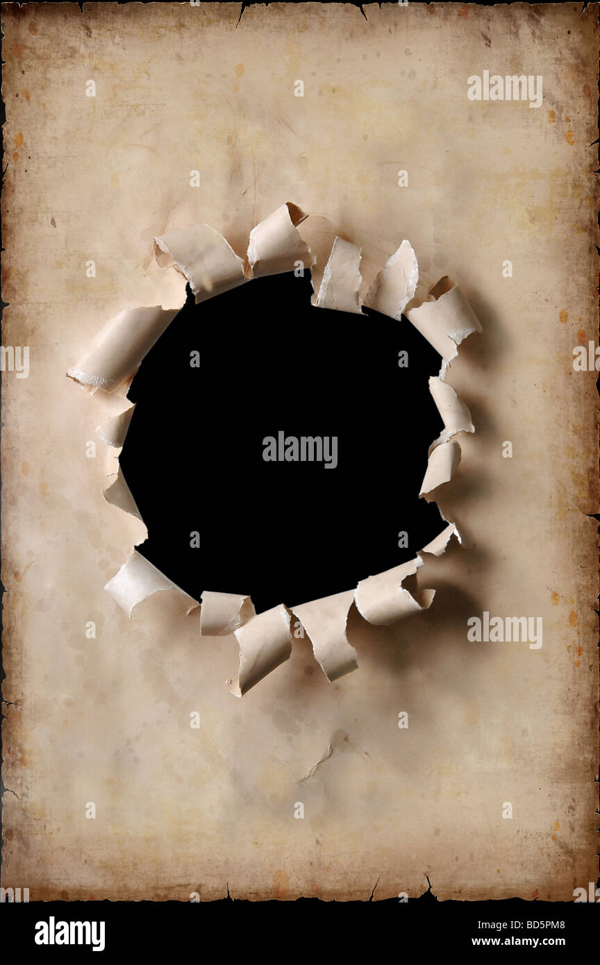 Vintage paper with a hole torn in the middle with black background ...