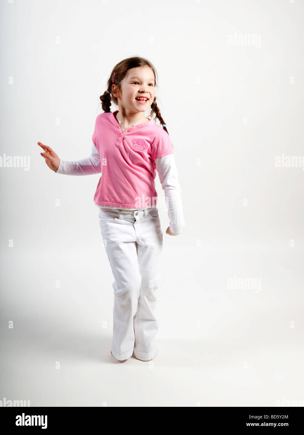 Young girl, 5 years old, performing on a white background. Smiling and ...