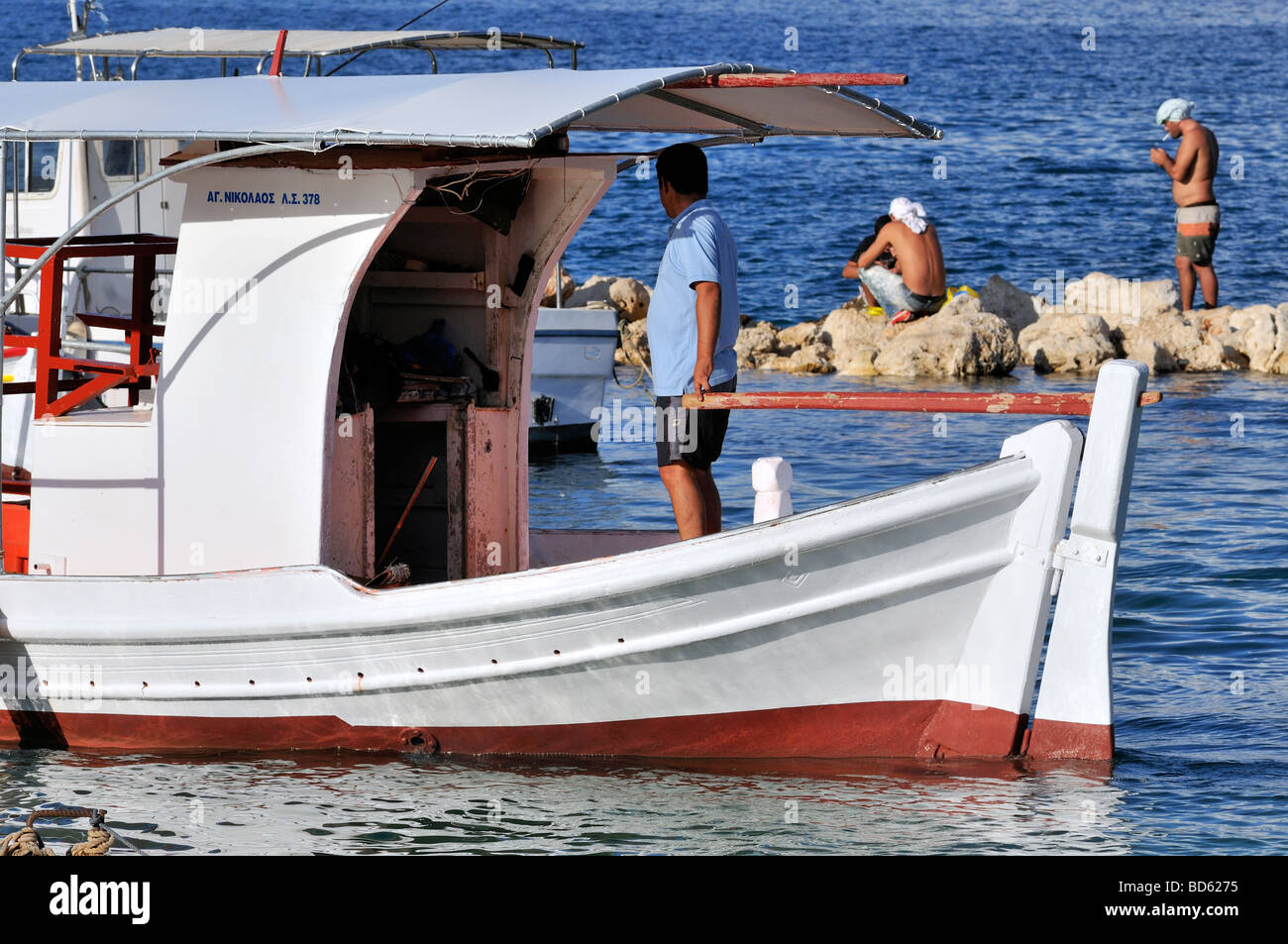 Greek fisherman with fishing boat in the Greek sea Stock Photo - Alamy