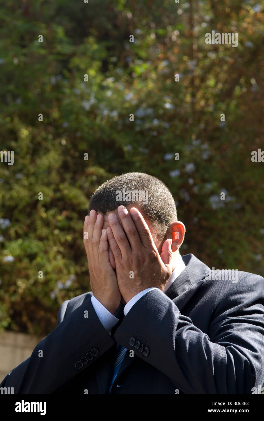 Business man head in hands outdoors Stock Photo - Alamy