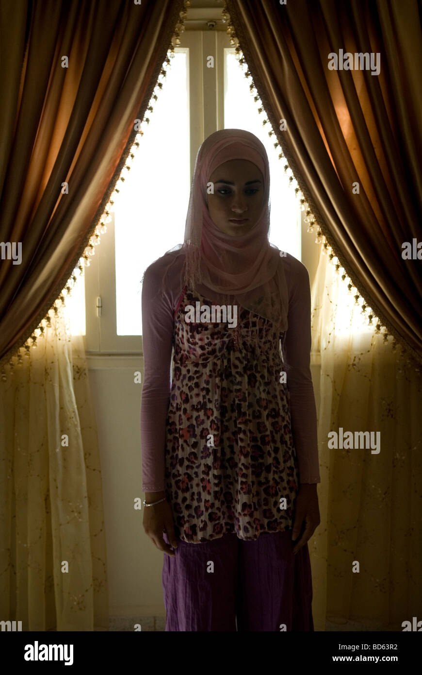 Young Muslim woman standing alone at home Stock Photo - Alamy
