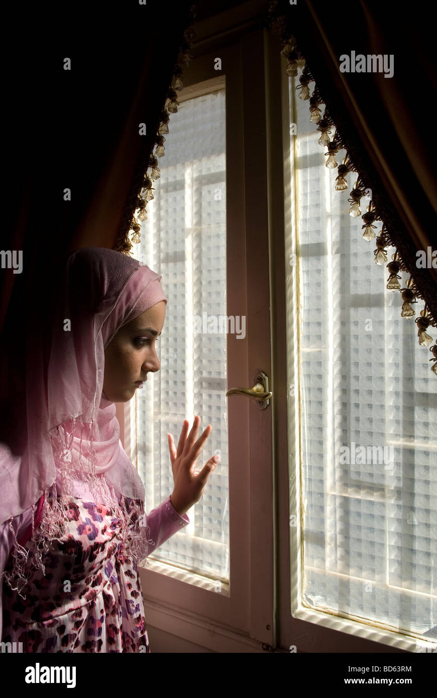 Young Muslim female by the window at home Stock Photo - Alamy