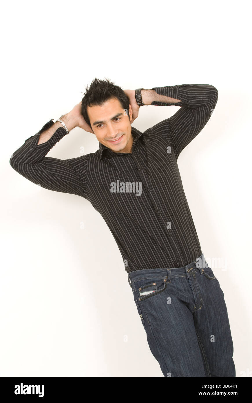 Happy man standing with hands behind his head against a white ...