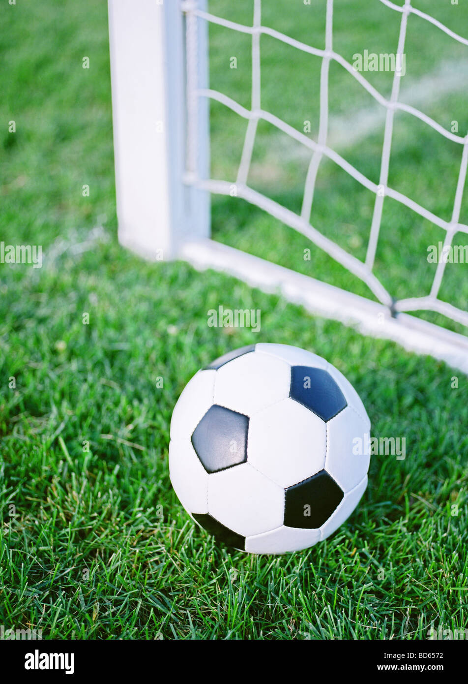 Soccer ball in the goal net, pole and net in close-up Stock Photo - Alamy