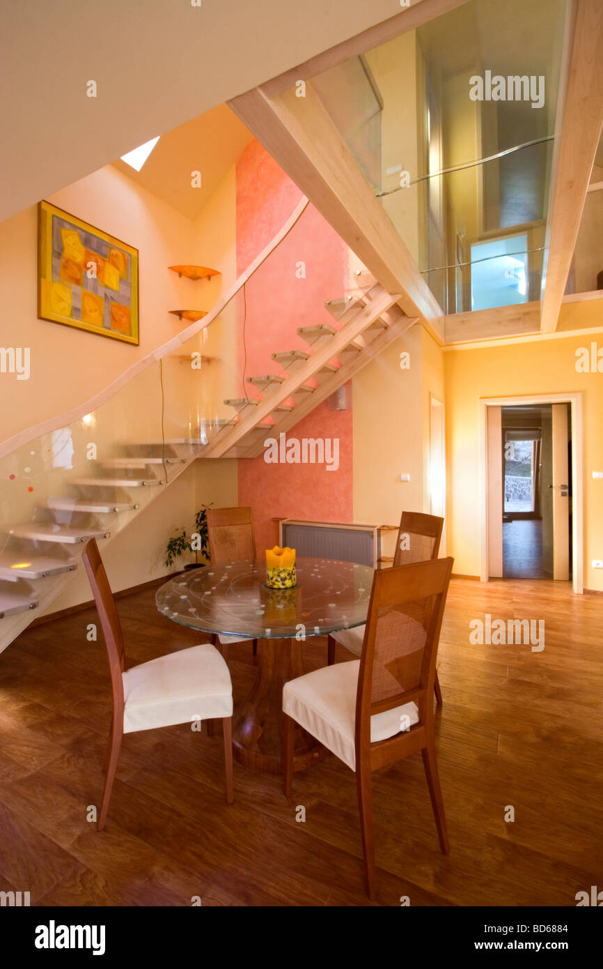Table with chairs in loft apartment Stock Photo - Alamy