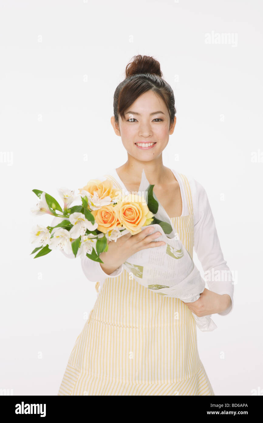 Young woman presenting flowers Stock Photo - Alamy