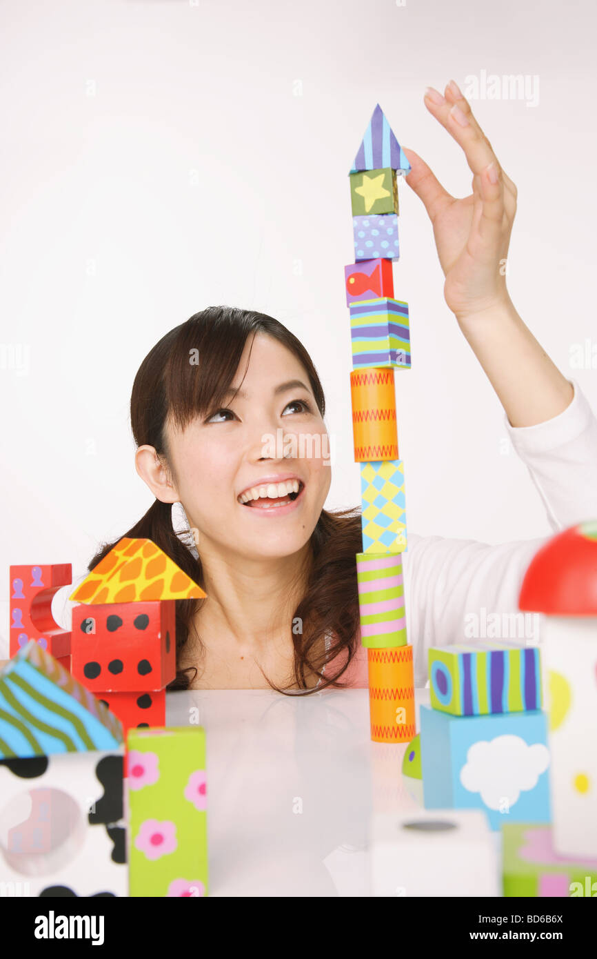 Cheerful lady playing with stack of wooden blocks Stock Photo - Alamy