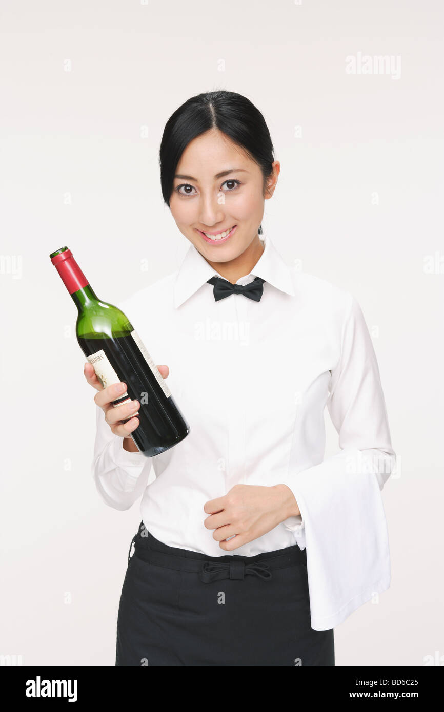Waitress holding bottle of wine with towel Stock Photo - Alamy