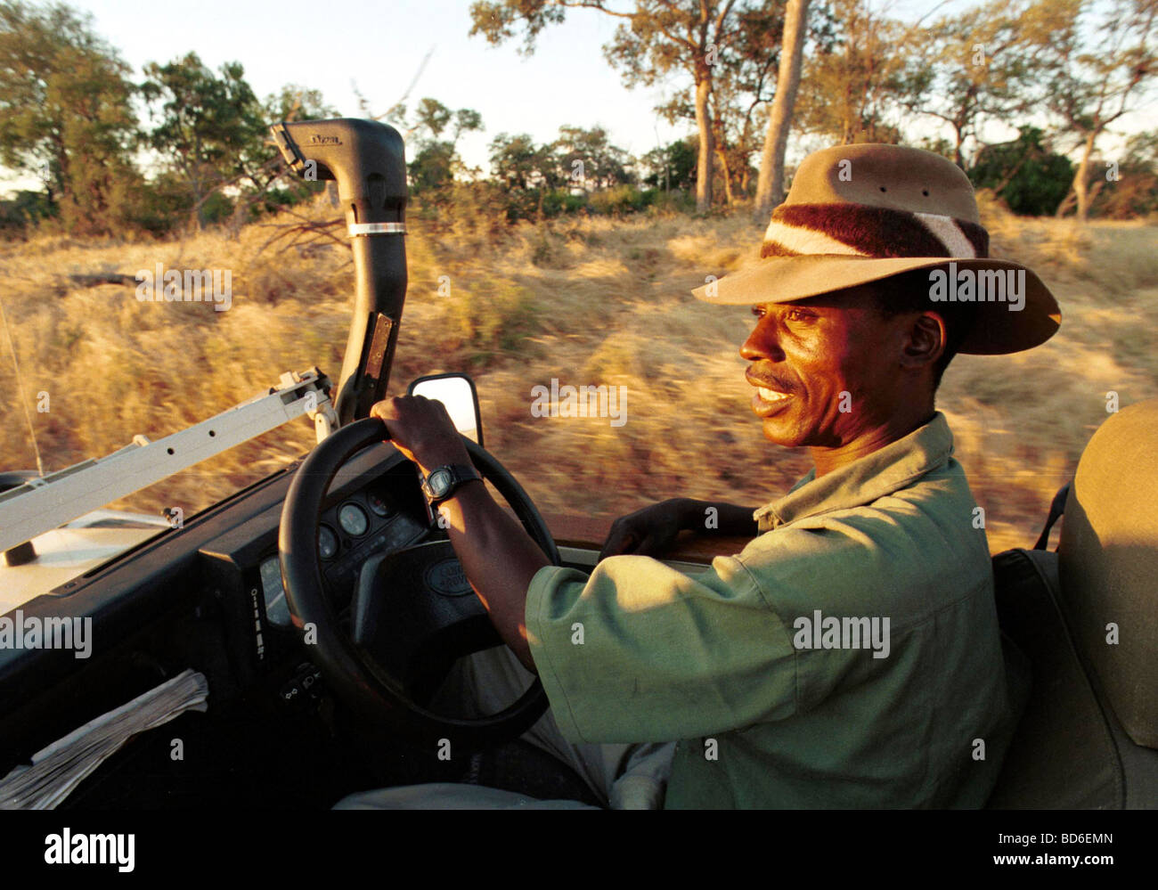 A safari guide drives tourists through a nature reserve in Botswana to ...