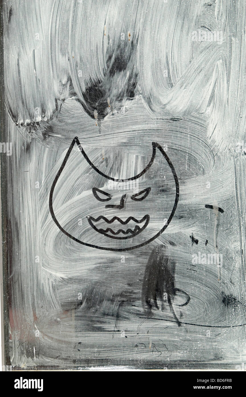 as scribble of a monster face for Halloween on a window during ...