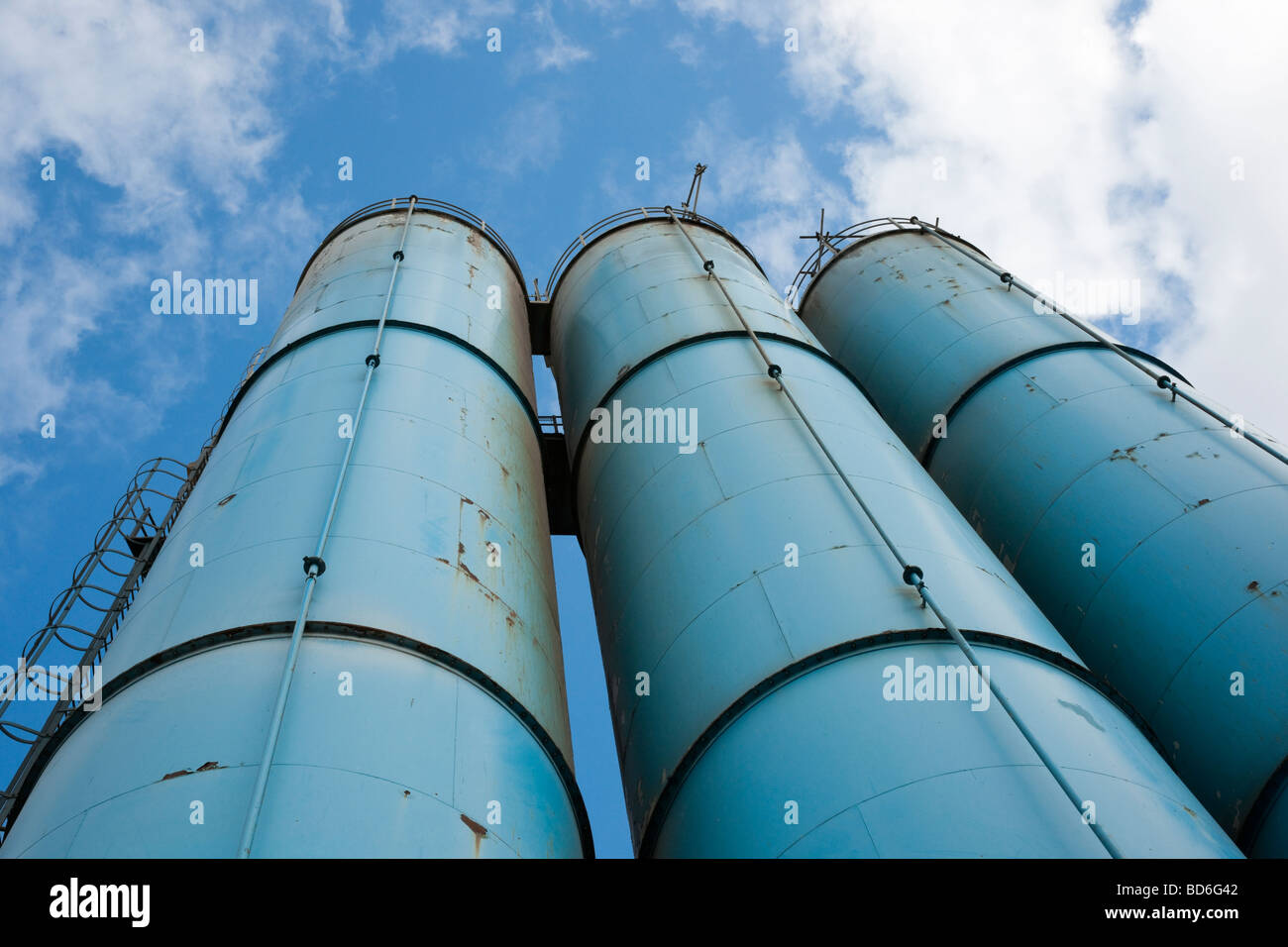 Three blue rusty silos against blue sky Stock Photo - Alamy