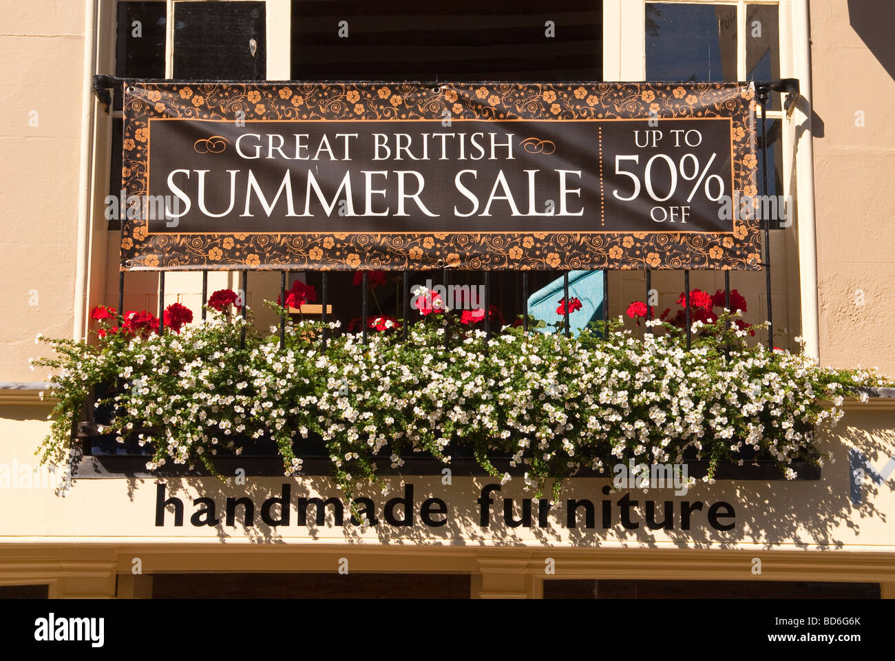 A pretty floral windowbox and a sale advert in a furniture shop in the ...