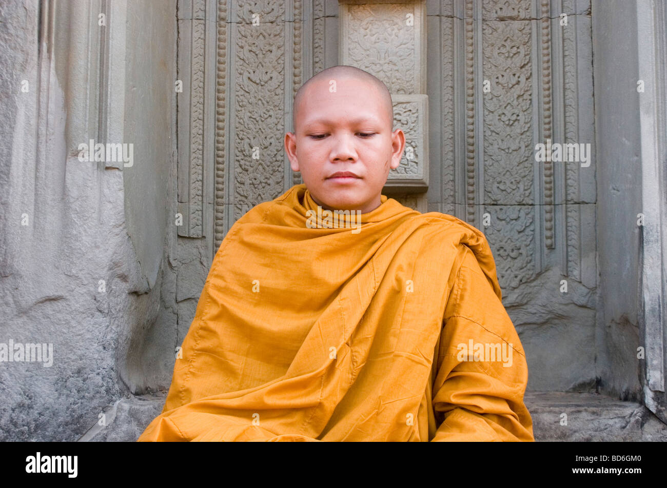 Young Buddhist monk Ronrom sits in a doorway at East Mebon, one of the ...
