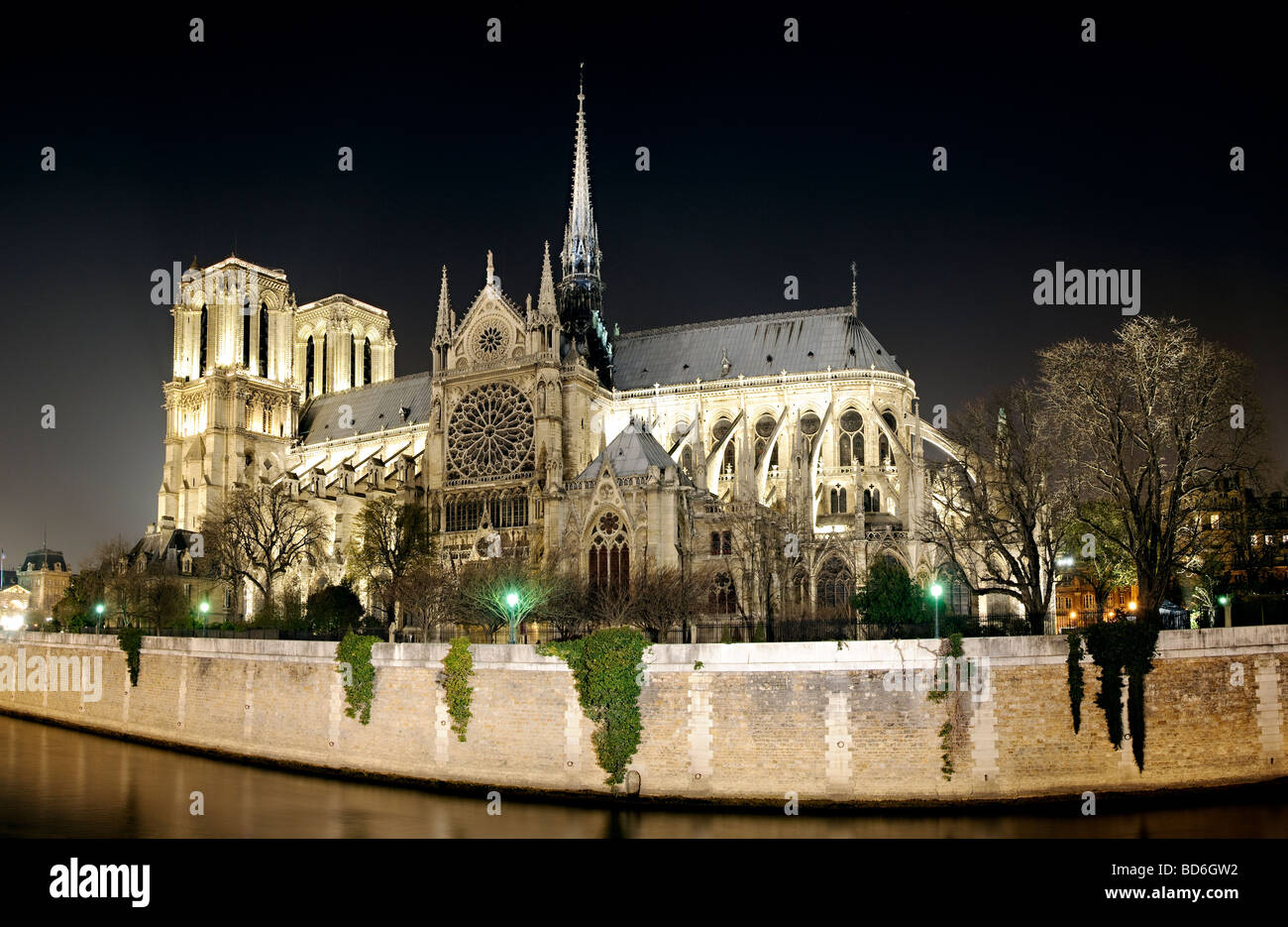 View of the back of Notre Dame to Paris at night looking down the Seine ...