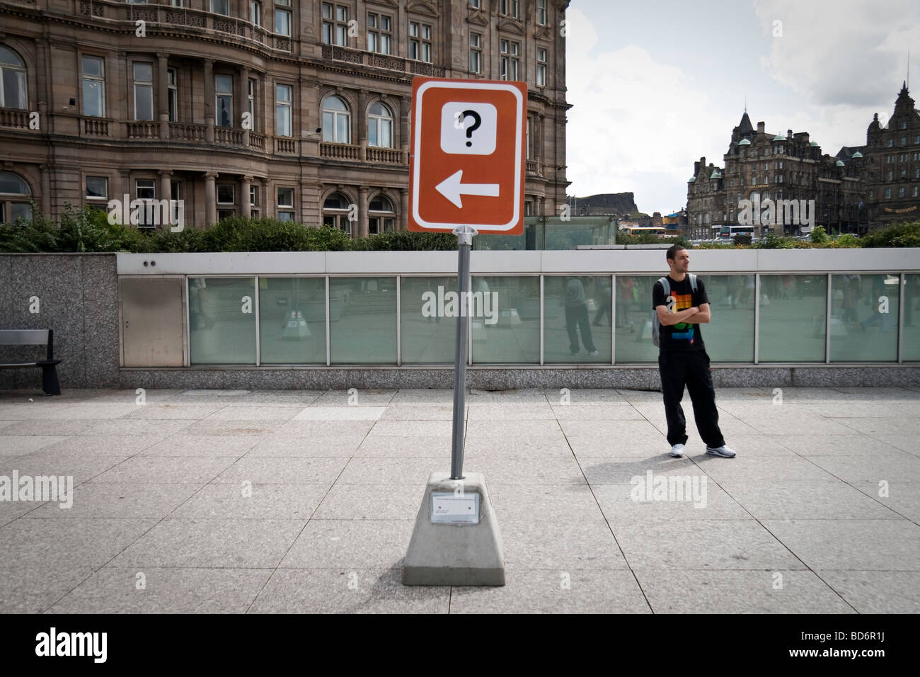A sign post with a question mark and arrow pointing left - in the ...