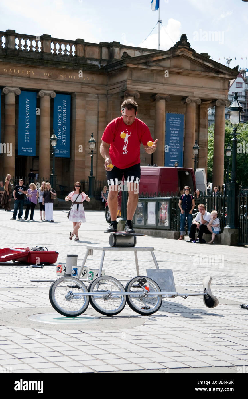 A street performer juggling and balancing during an act outside the ...