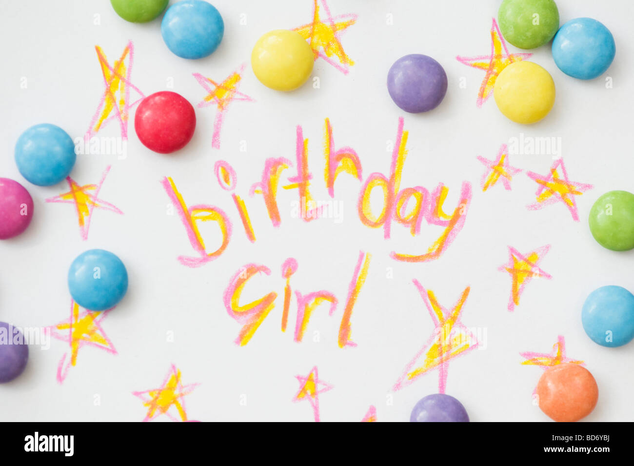 Birthday girl, stars and smarties written in coloured pencils on paper ...