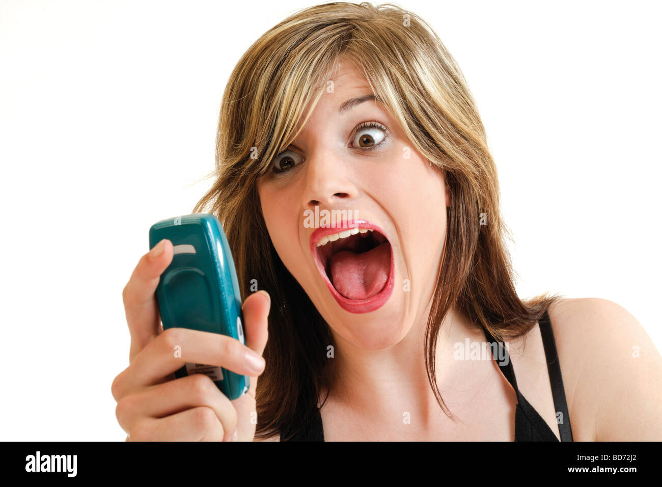 Young woman screaming while holding a cellphone in her hand Stock Photo ...