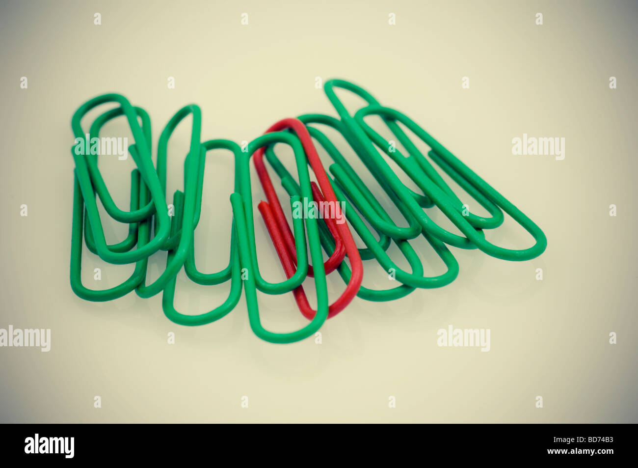 Red paperclip in a pile of green clips Stock Photo - Alamy
