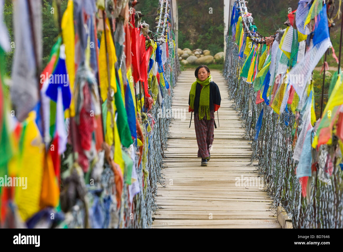 Crossing suspension bridge decorated with prayer flags nr Jakar ...