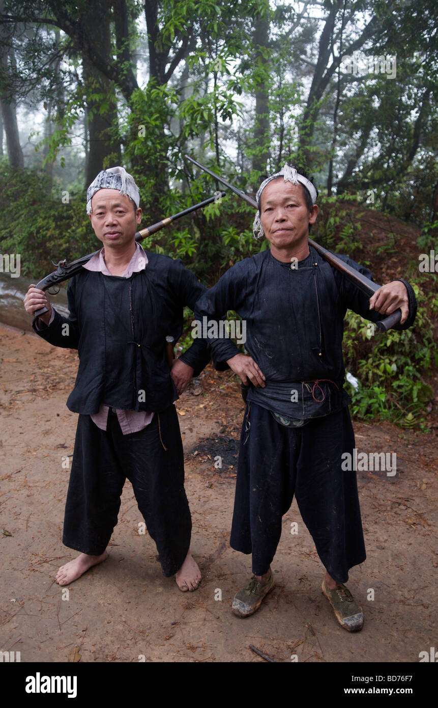 Two Basha Miao men carrying guns Congjiang County Guizhou Province ...