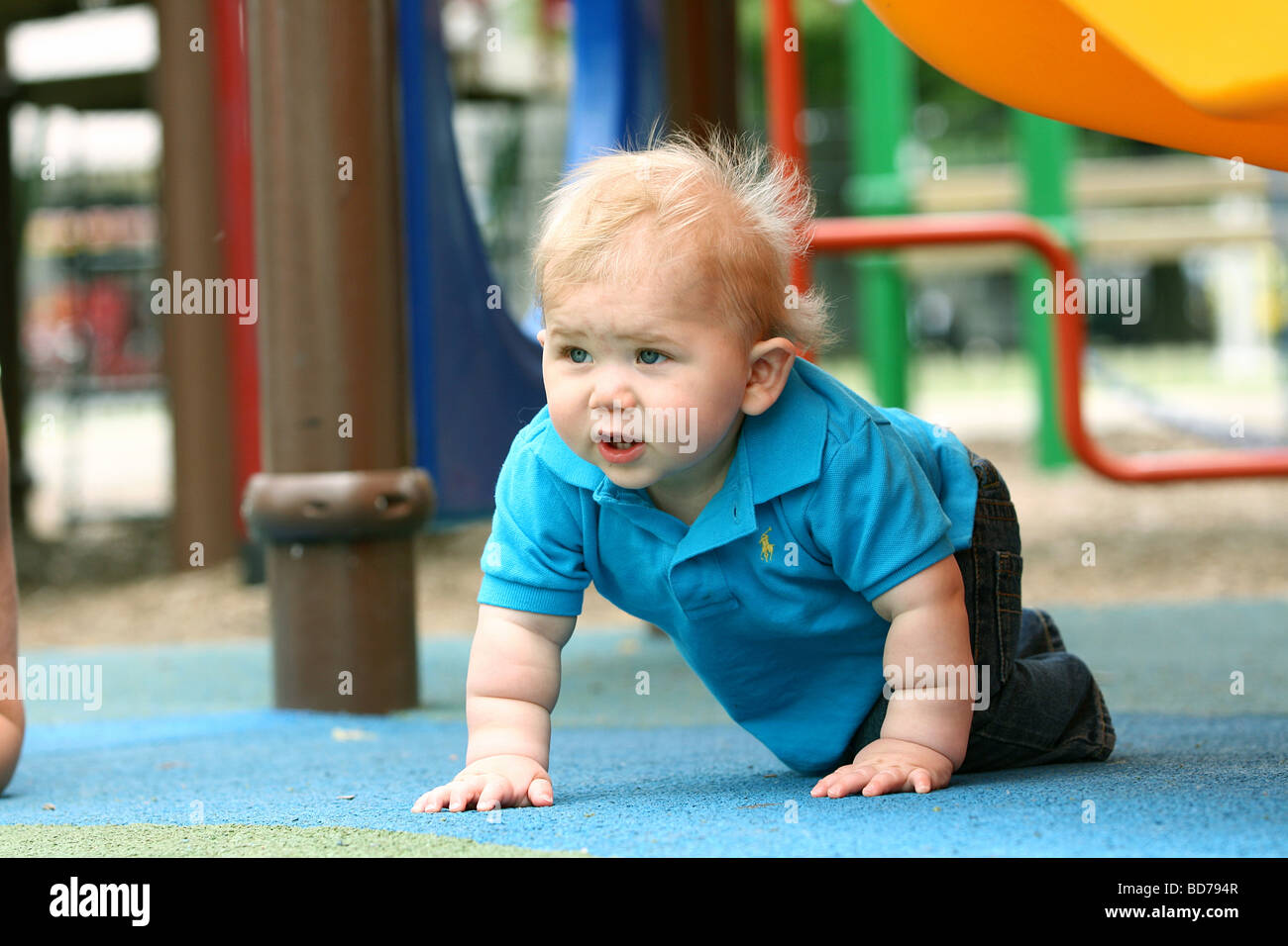 Baby boy crawling around playground Stock Photo - Alamy