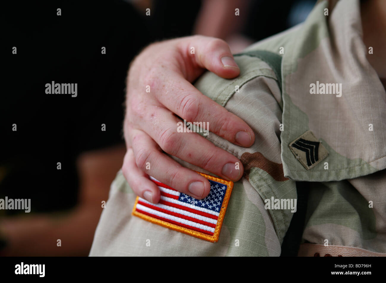 A supporter rests a hand on the shoulder of a soldier just home from ...