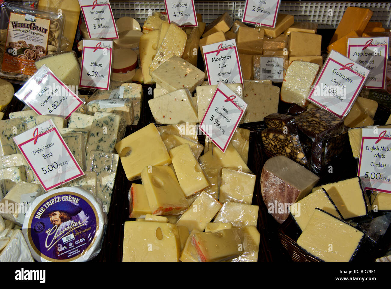 Delicatessen specialty imported cheeses in open stainless steel display ...