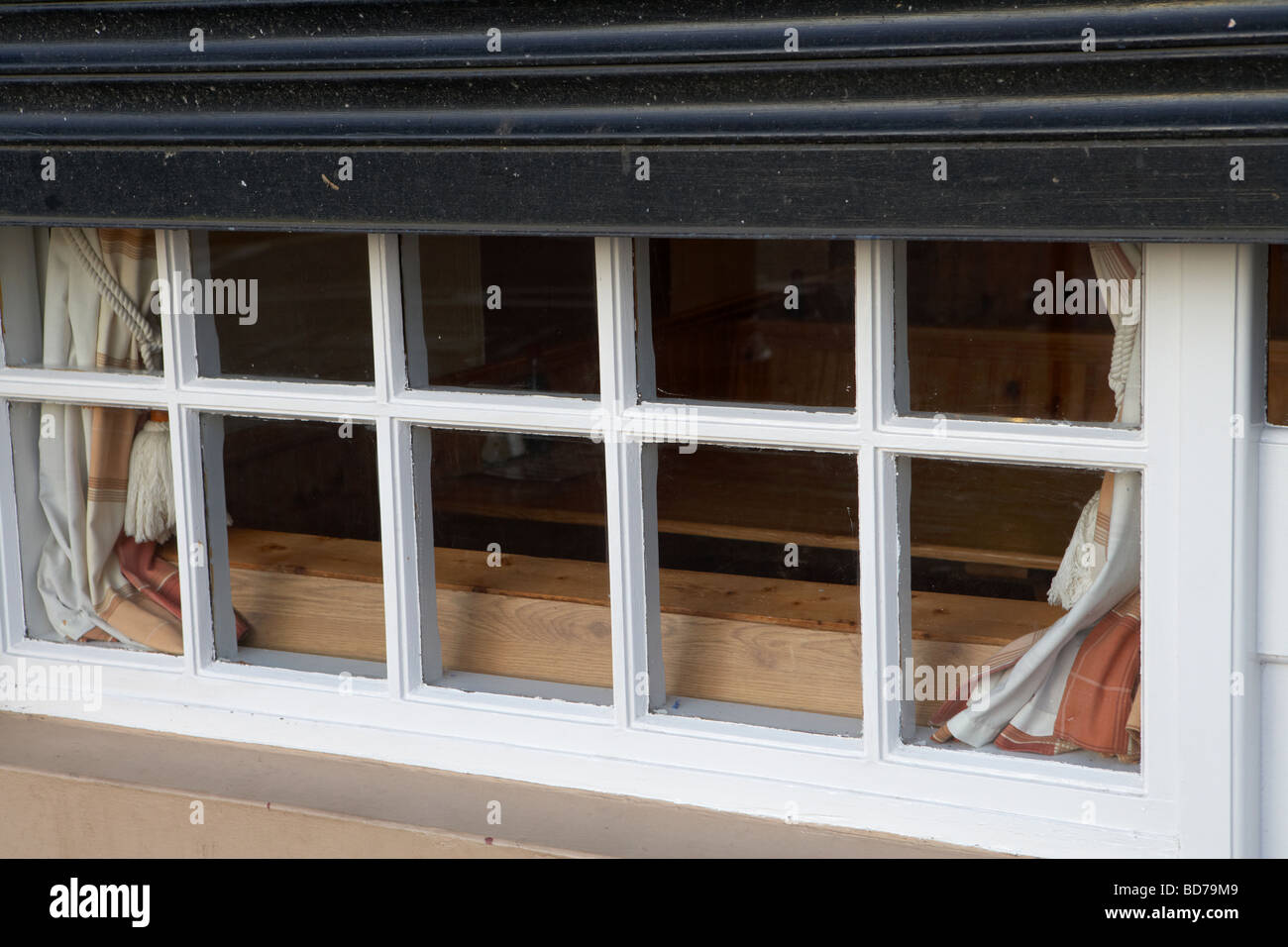 metal security shutter half open or closed over a white painted ...