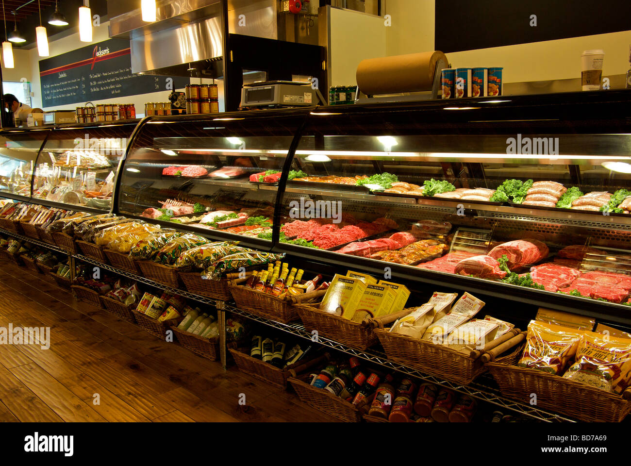 Reflections and distortions from illuminated glass fronted meat display cooler cases in butcher ...
